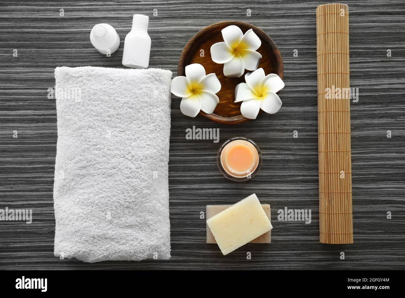 Spa set with nutrient cream, soap and flowers on wooden background ...