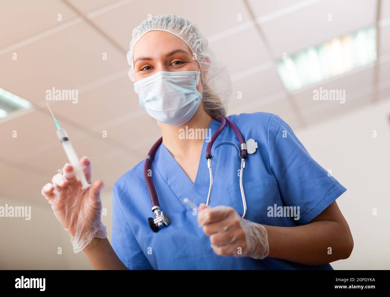 Female nurse in mask holding syringe for injection Stock Photo - Alamy