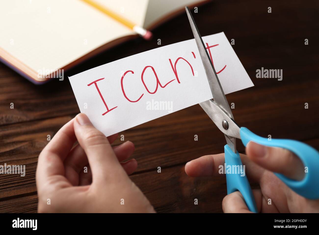 Hand cutting phrase I CAN'T on wooden background Stock Photo - Alamy