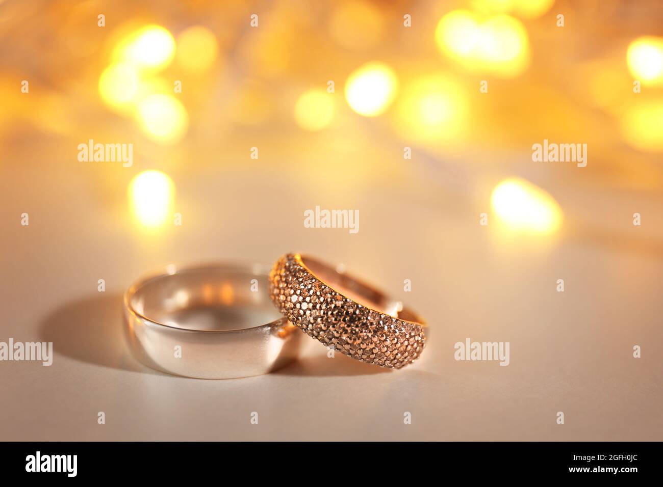 Wedding rings and blurred lights on white background Stock Photo - Alamy
