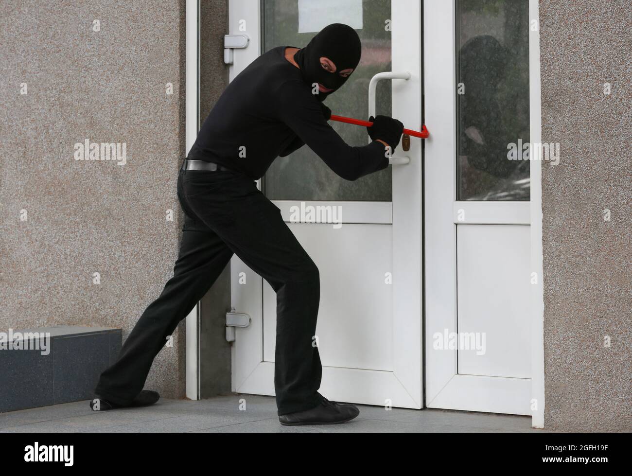 Armed thief breaking a door Stock Photo - Alamy