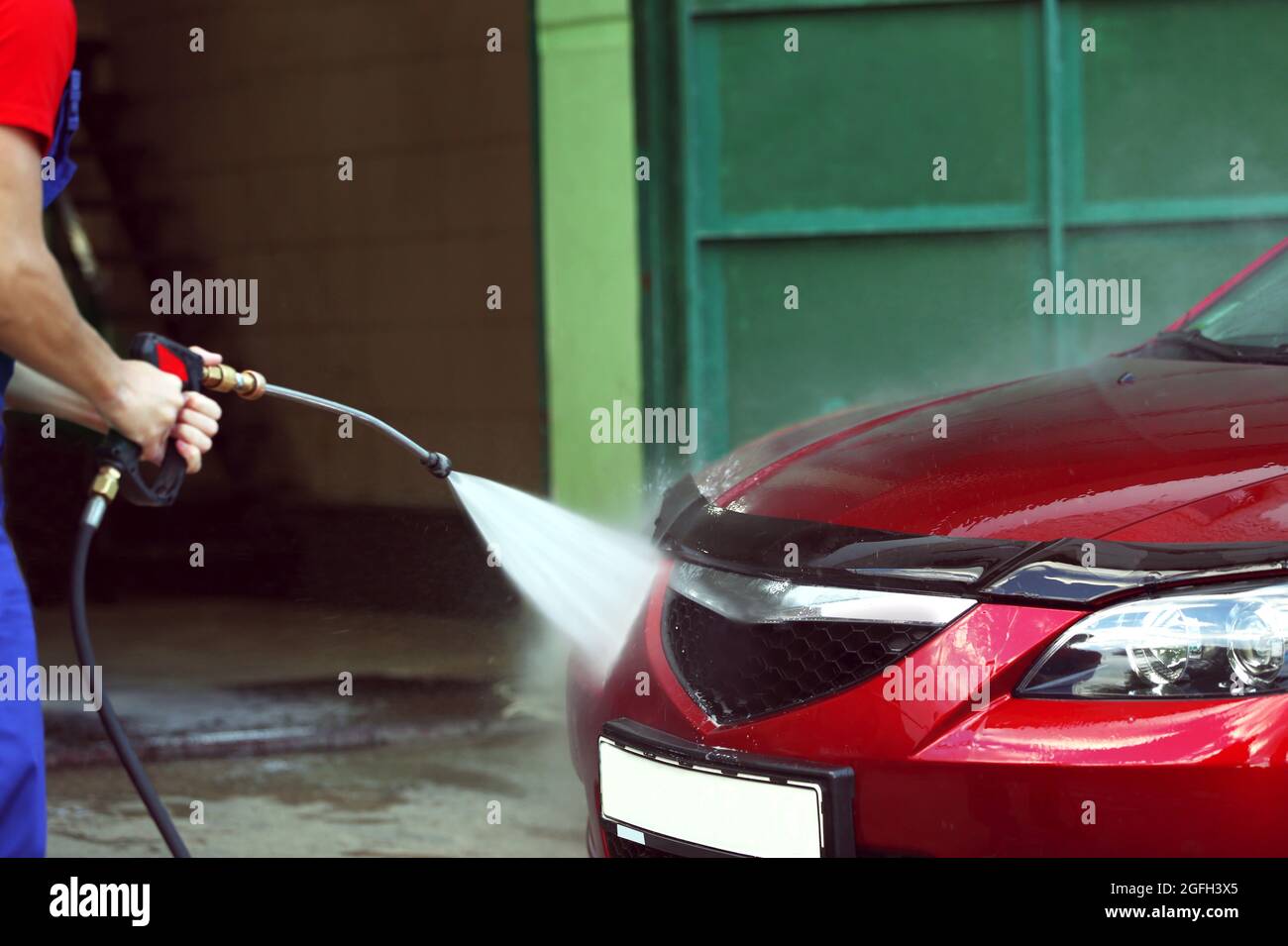 Serviceman cleaning car using high pressure water Stock Photo - Alamy