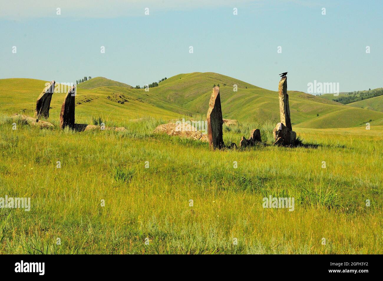 Ancient burial stones stand as burial fences in the hilly steppe ...