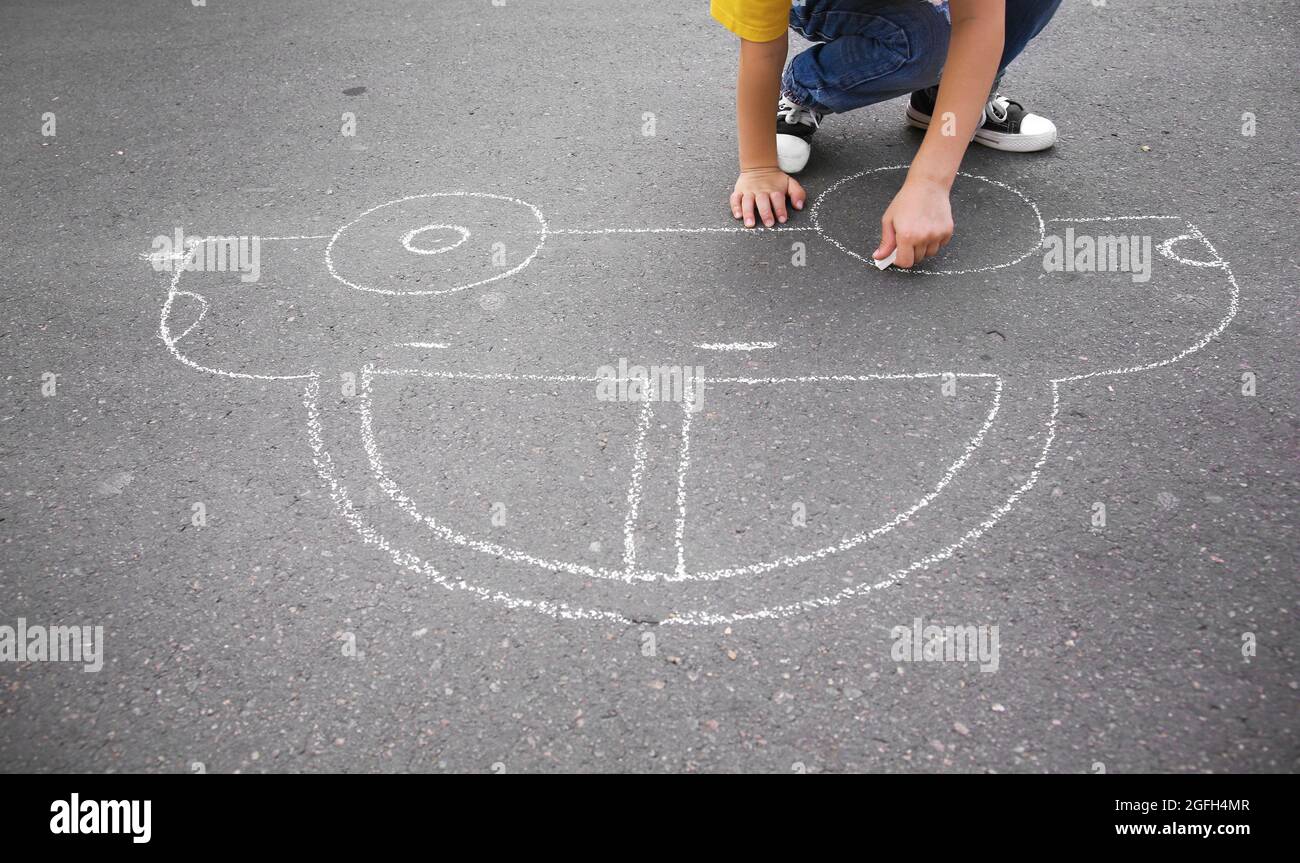 Boy with chalk drawing car Stock Photo - Alamy