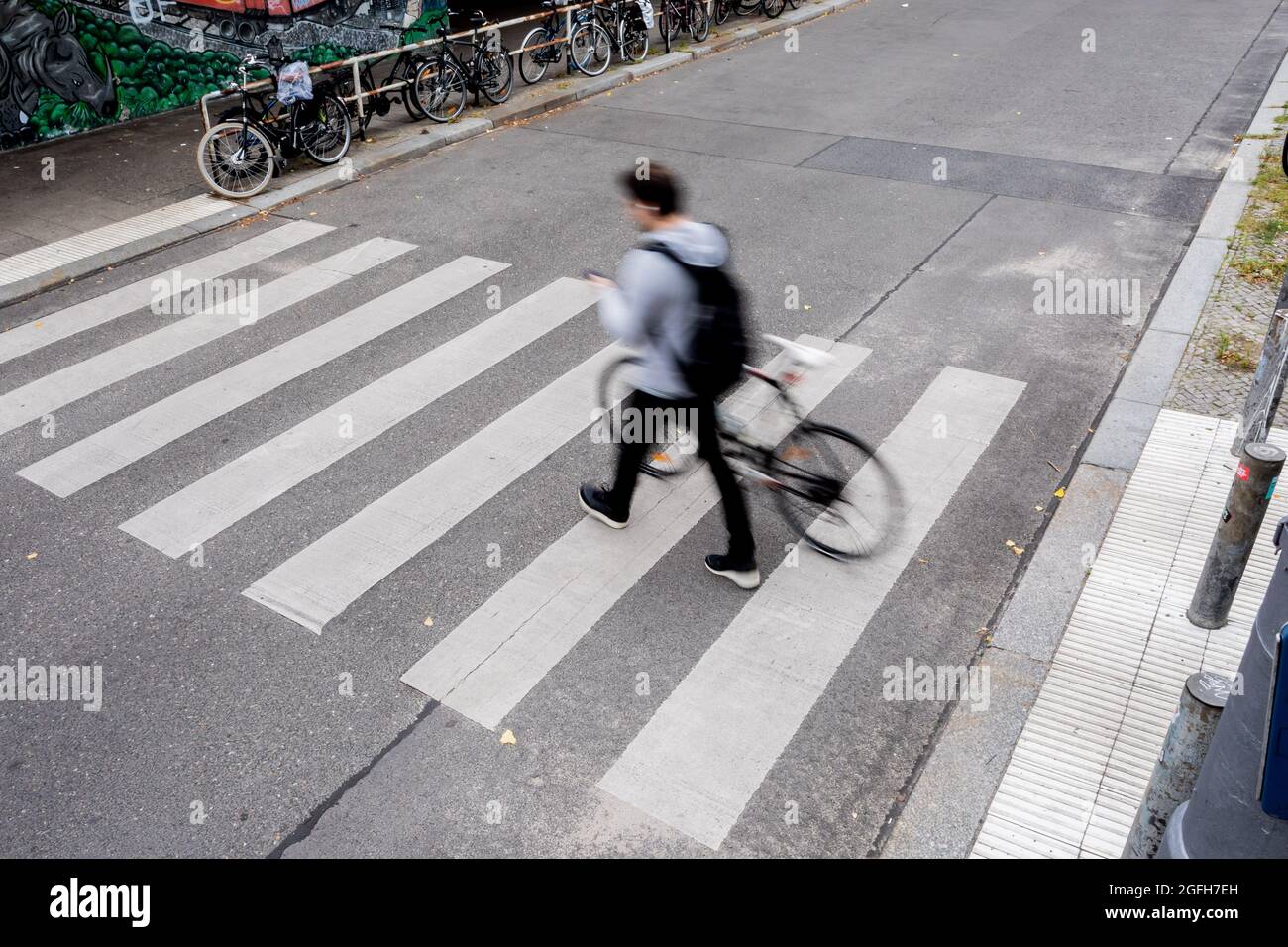 Berlin, Germany. 25th Aug, 2021. A cyclist pushes his bike across a ...