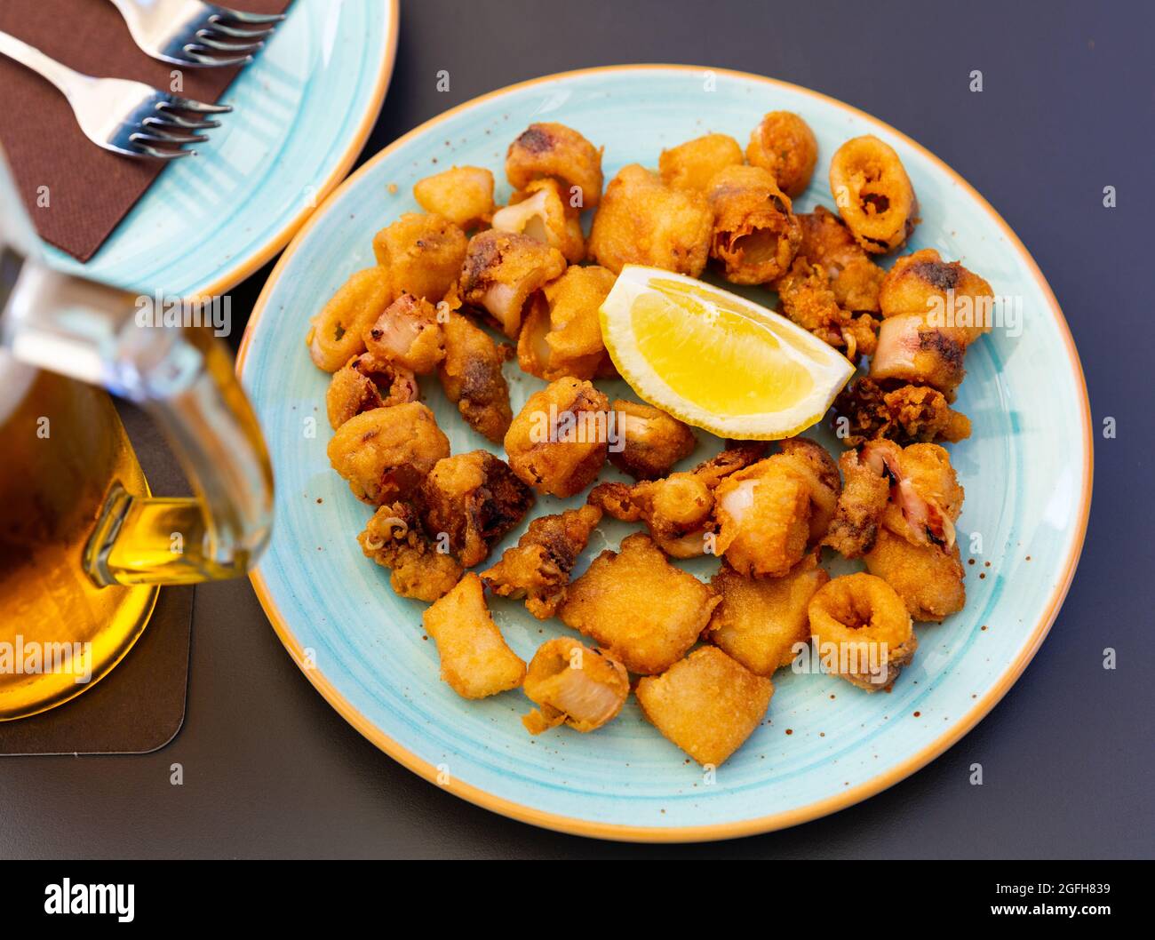 Chipirones, breaded fried calamari with lemon Stock Photo - Alamy