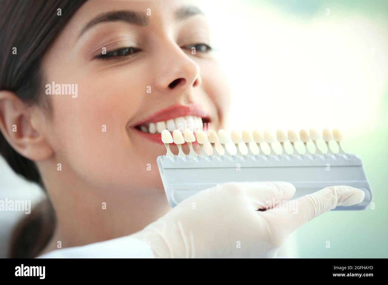 Dentist matching teeth colour in office Stock Photo - Alamy