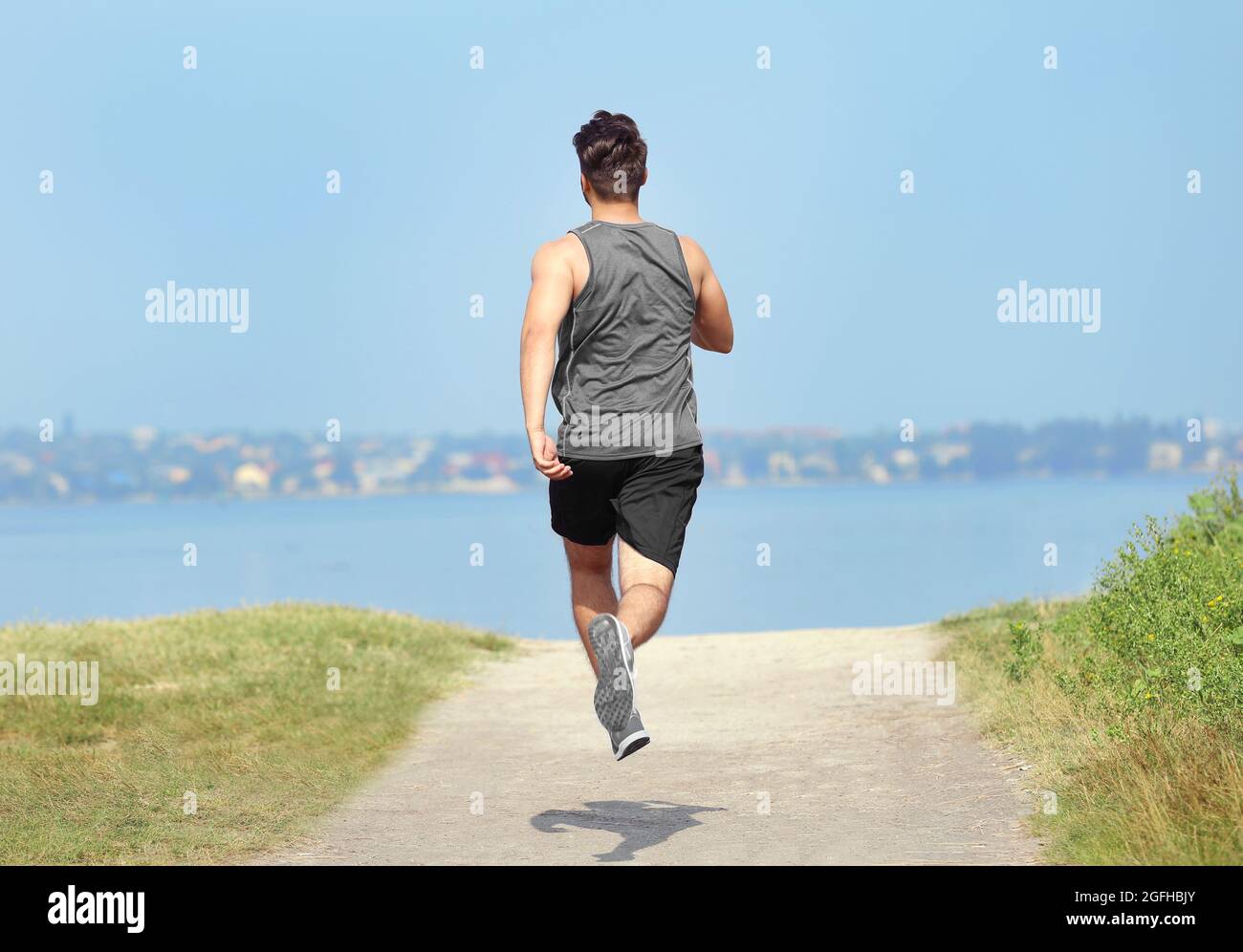 Man jogging on river background Stock Photo - Alamy