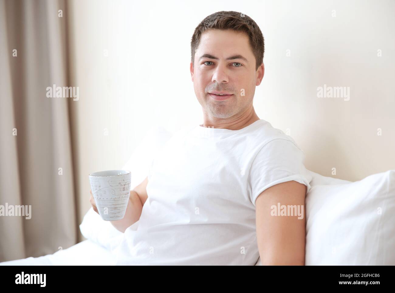 Handsome man tasting morning coffee Stock Photo - Alamy