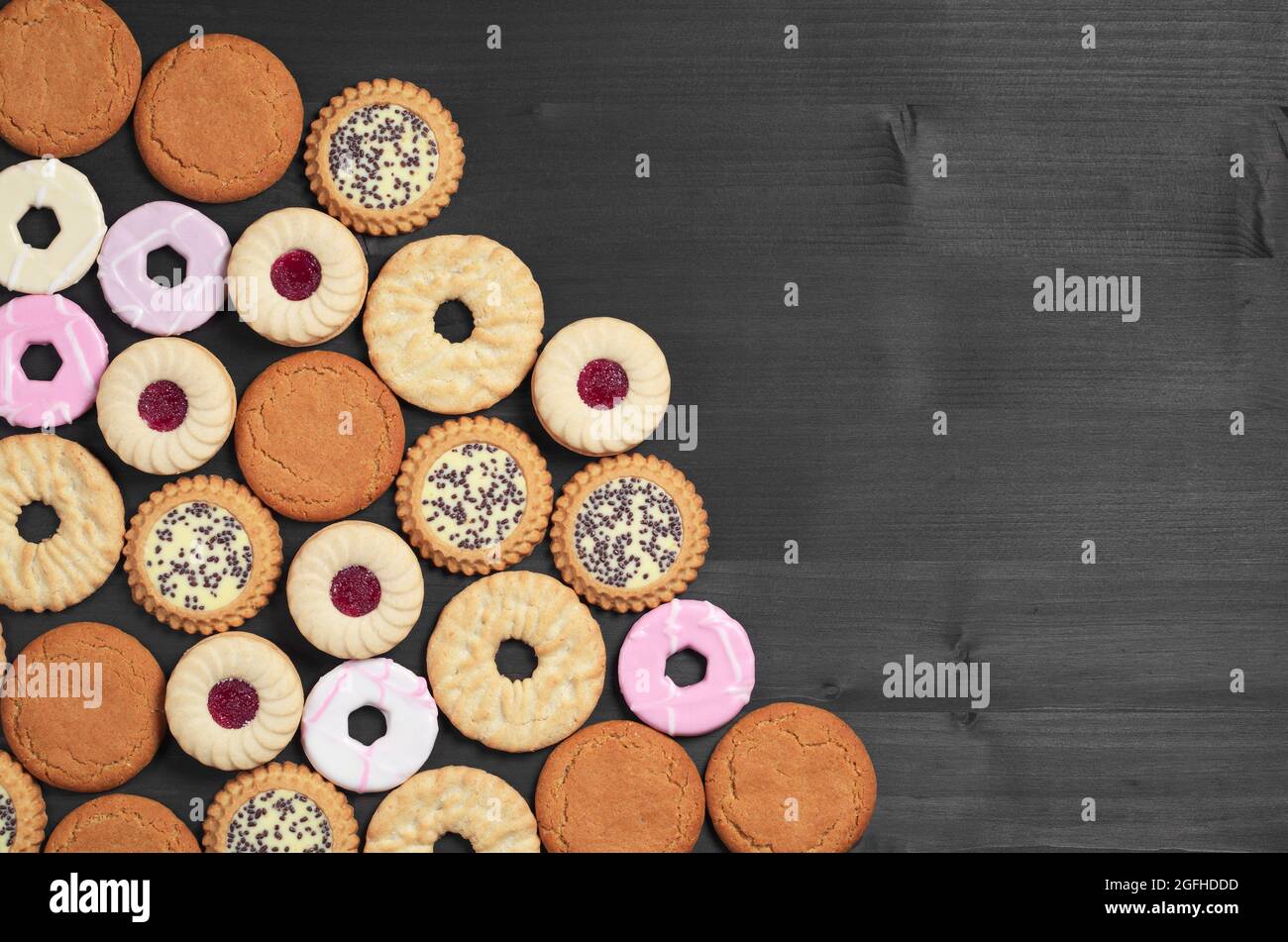 Different biscuits on black wooden table, top view with space for text ...