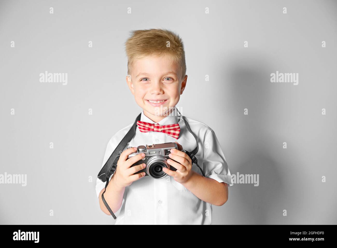 Little boy with vintage camera on grey background Stock Photo - Alamy