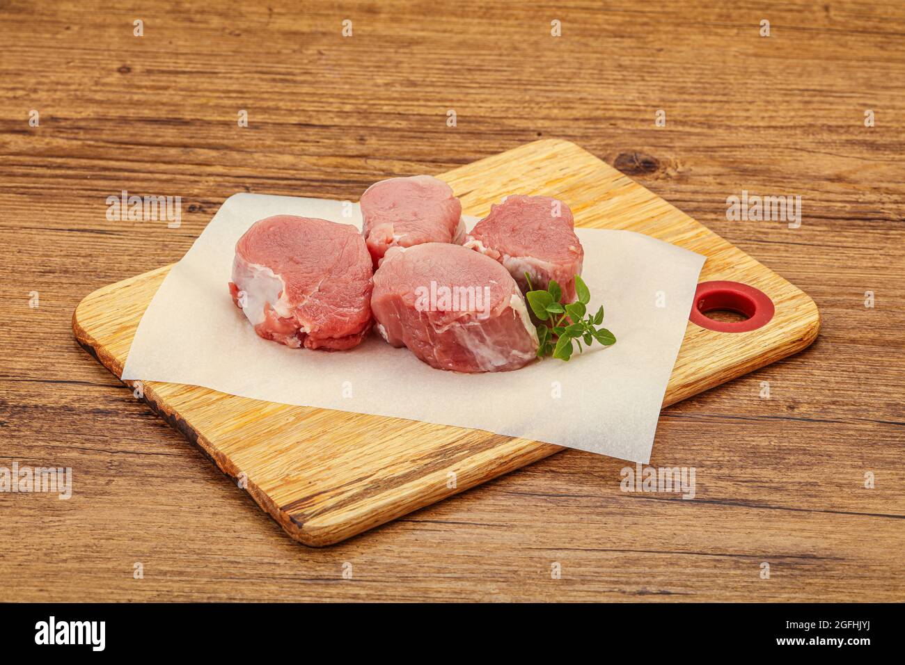 Raw pork medallion served rosemary for cooking Stock Photo - Alamy