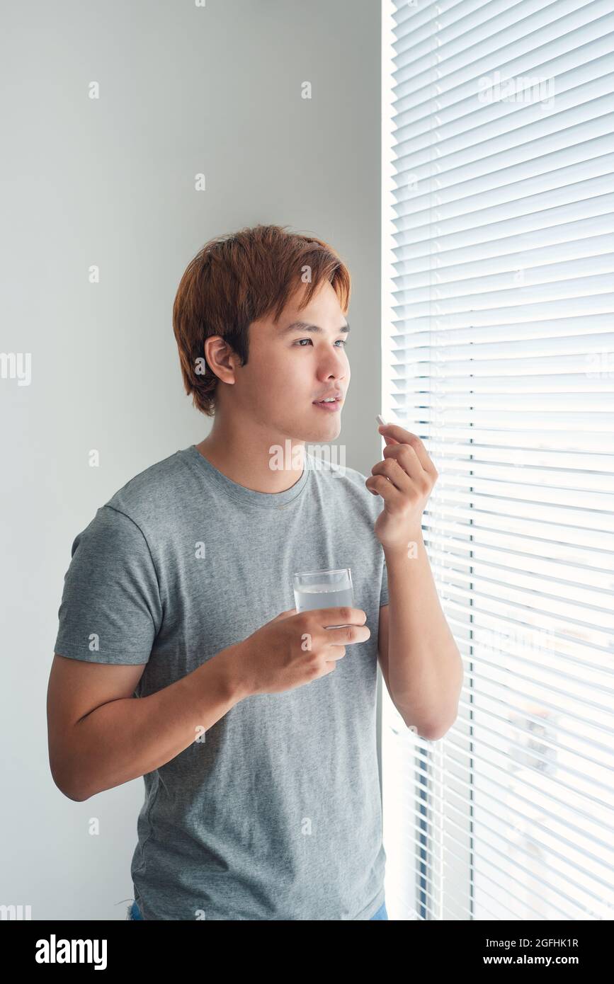 A man is eating a pill Stock Photo - Alamy