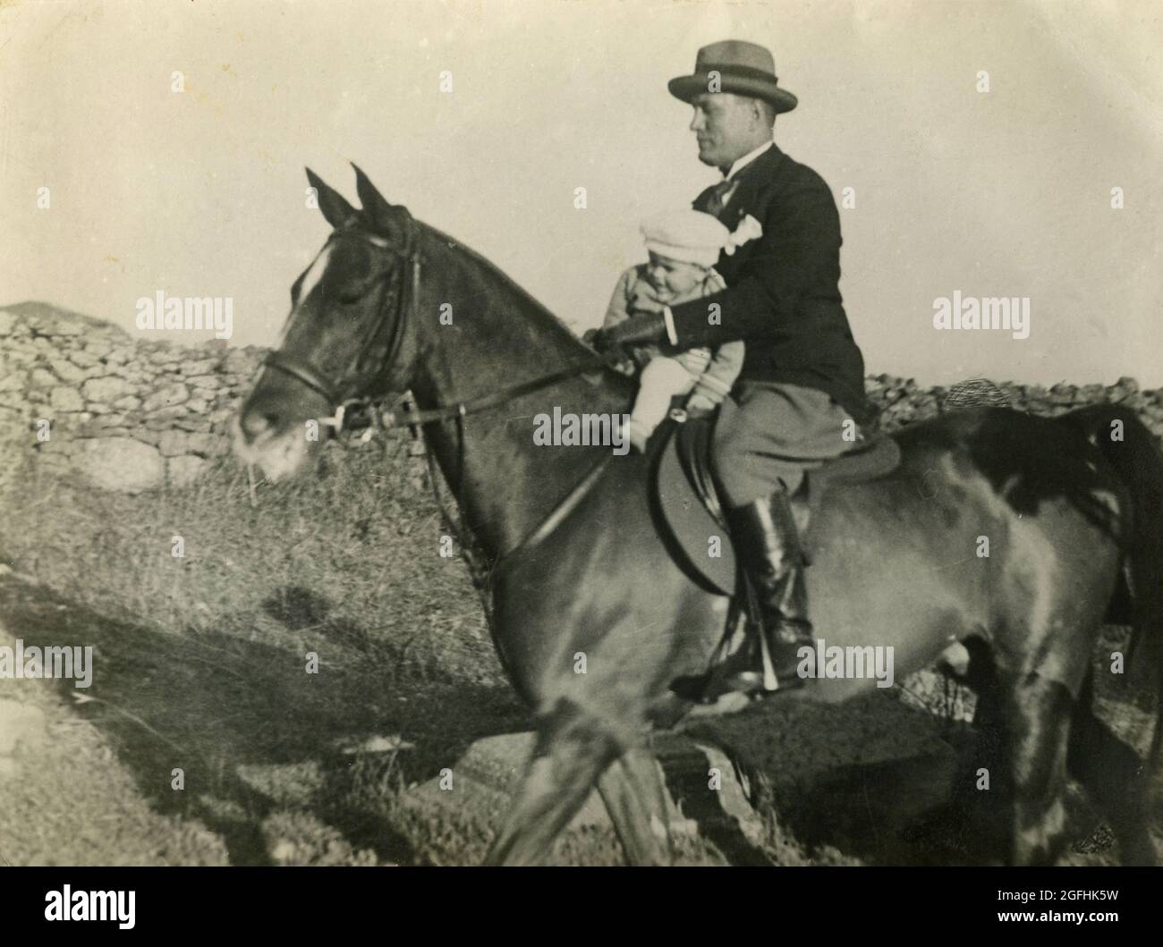 Italian dictator Benito Mussolini riding a horse with a small child ...