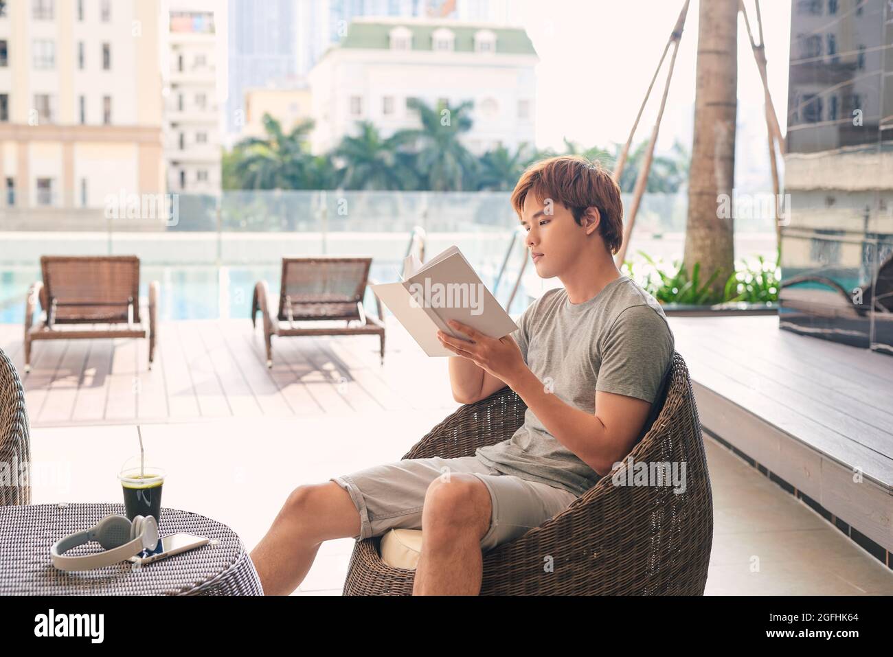 Man reading book near swimming pool. Relax concept Stock Photo - Alamy