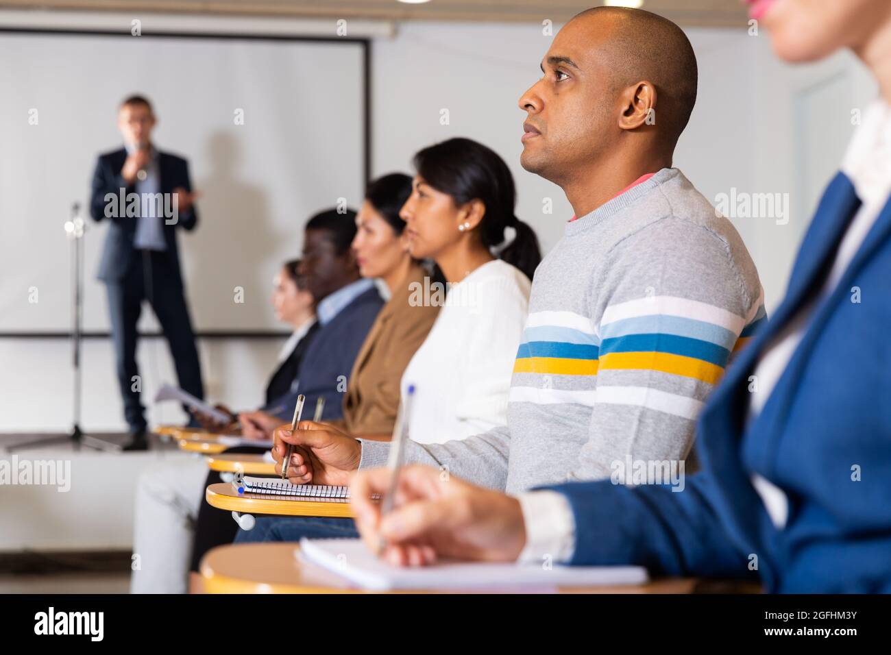 Focused man listening to lecture at conference Stock Photo - Alamy