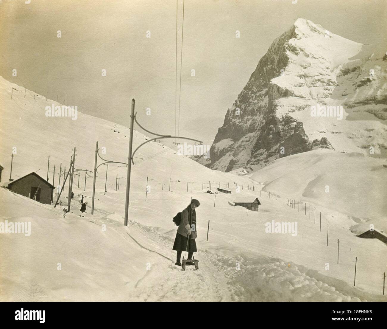 Woman walking a sledge on the snow track, Steinenwaldweg, Switzerland ...