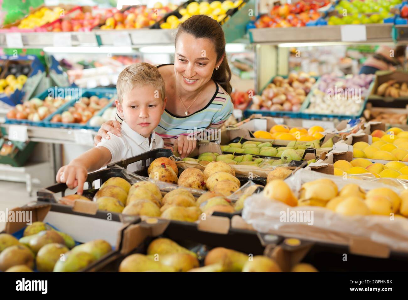 Positive boy with his mother choosing fruits Stock Photo - Alamy