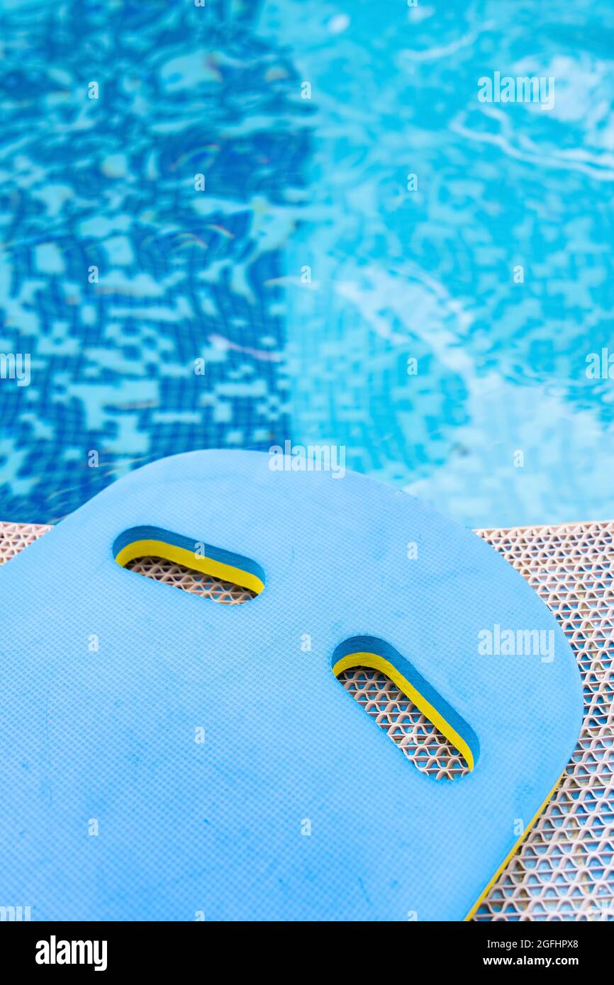 angle view blue floating pad near a swimming pool vertical composition ...