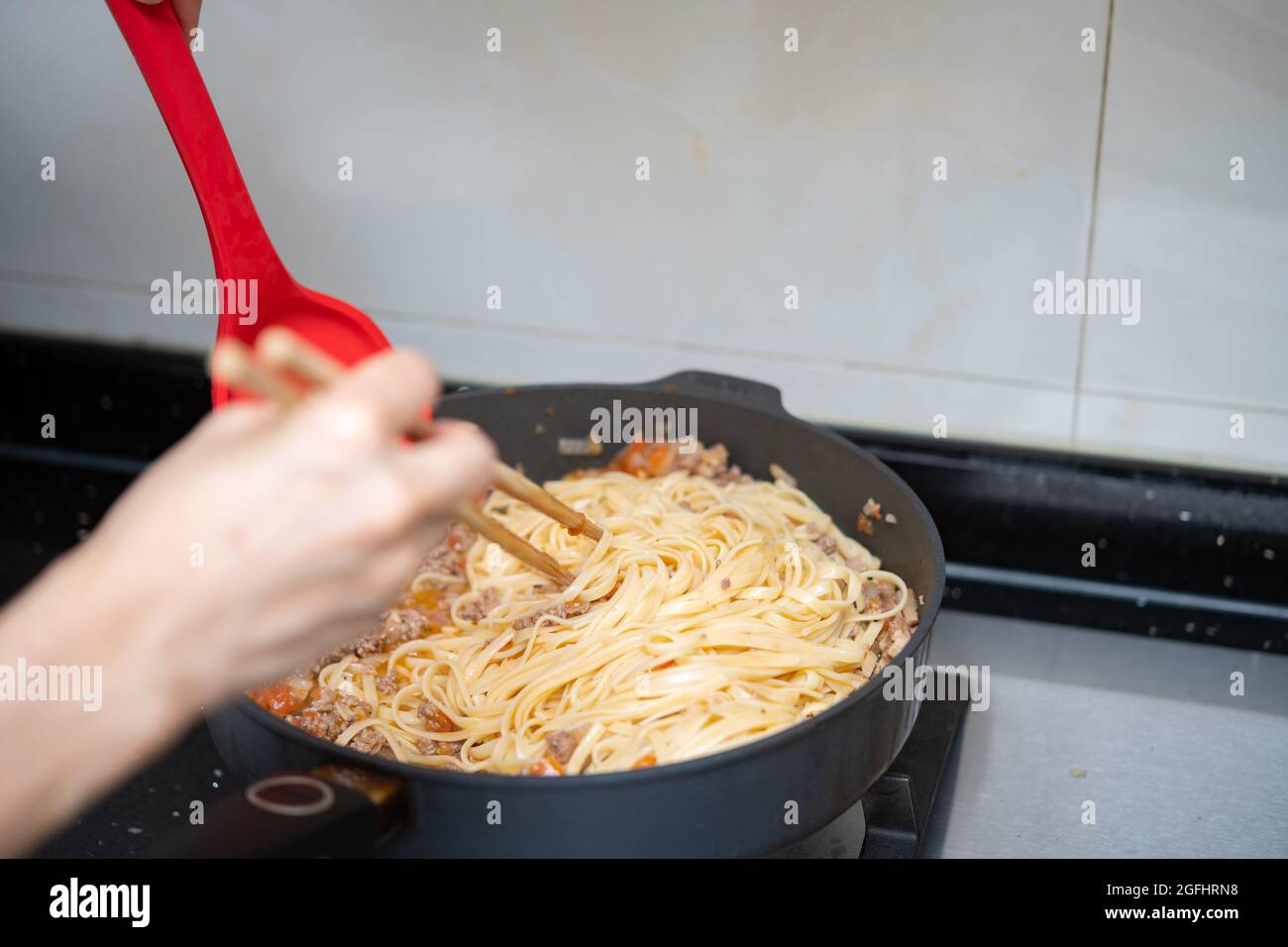 lady cooking a healthy Italian spaghetti with smashed pork at home ...