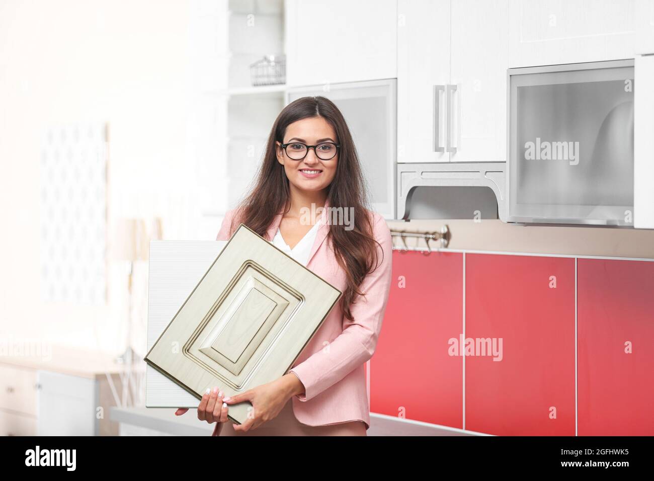 Beautiful female designer with wooden sample in office Stock Photo - Alamy