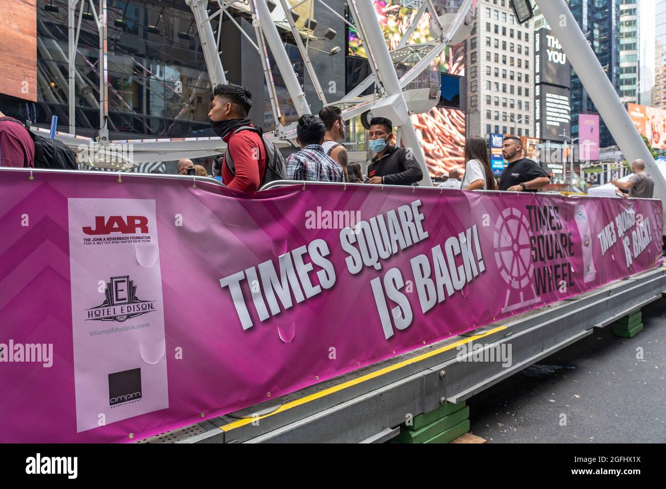 People wait to ride the Times Square Ferris wheel on opening day in ...