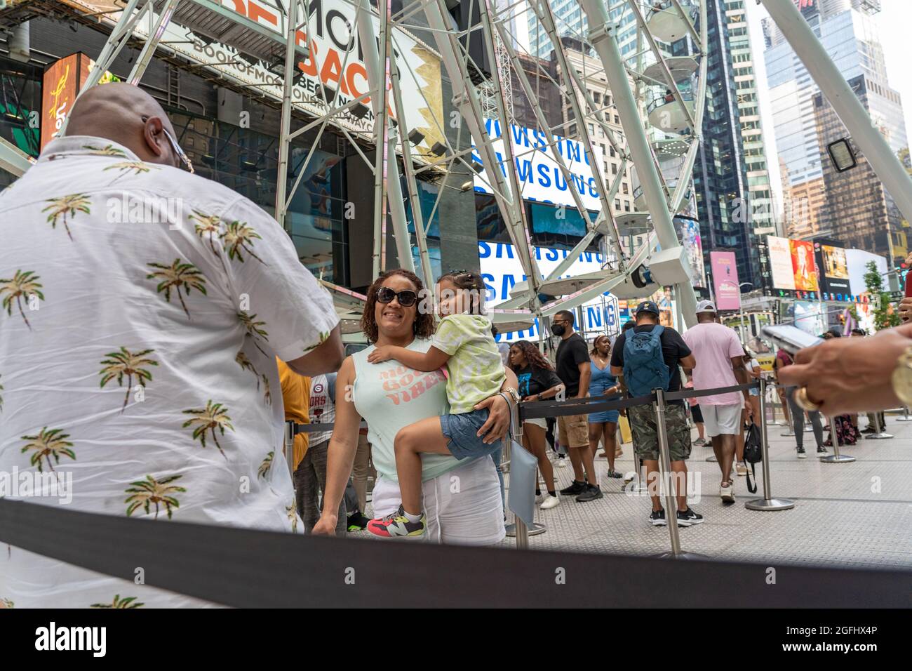 New York, United States. 25th Aug, 2021. A woman carrying a kid pose ...
