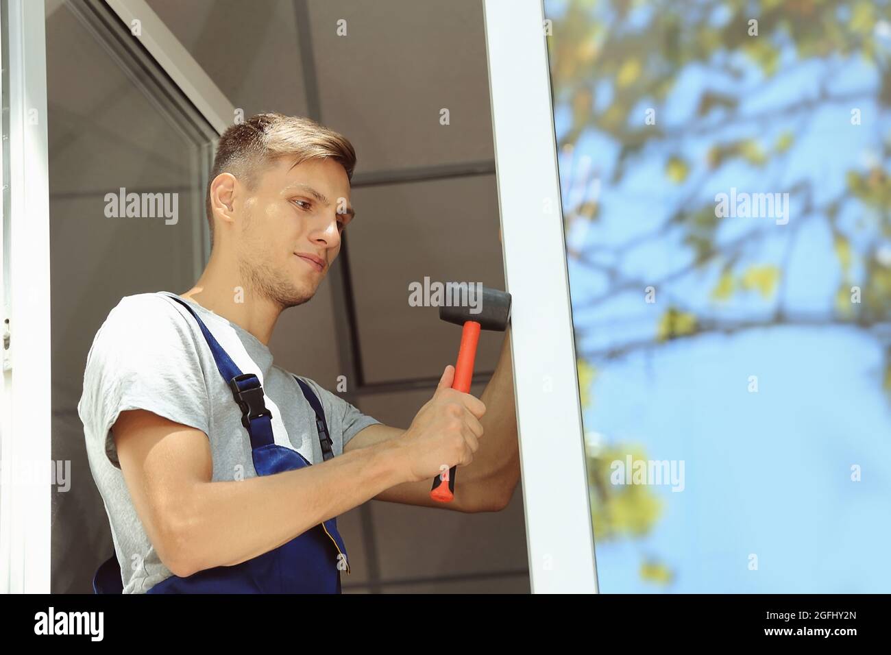 Construction worker installing window in house Stock Photo - Alamy