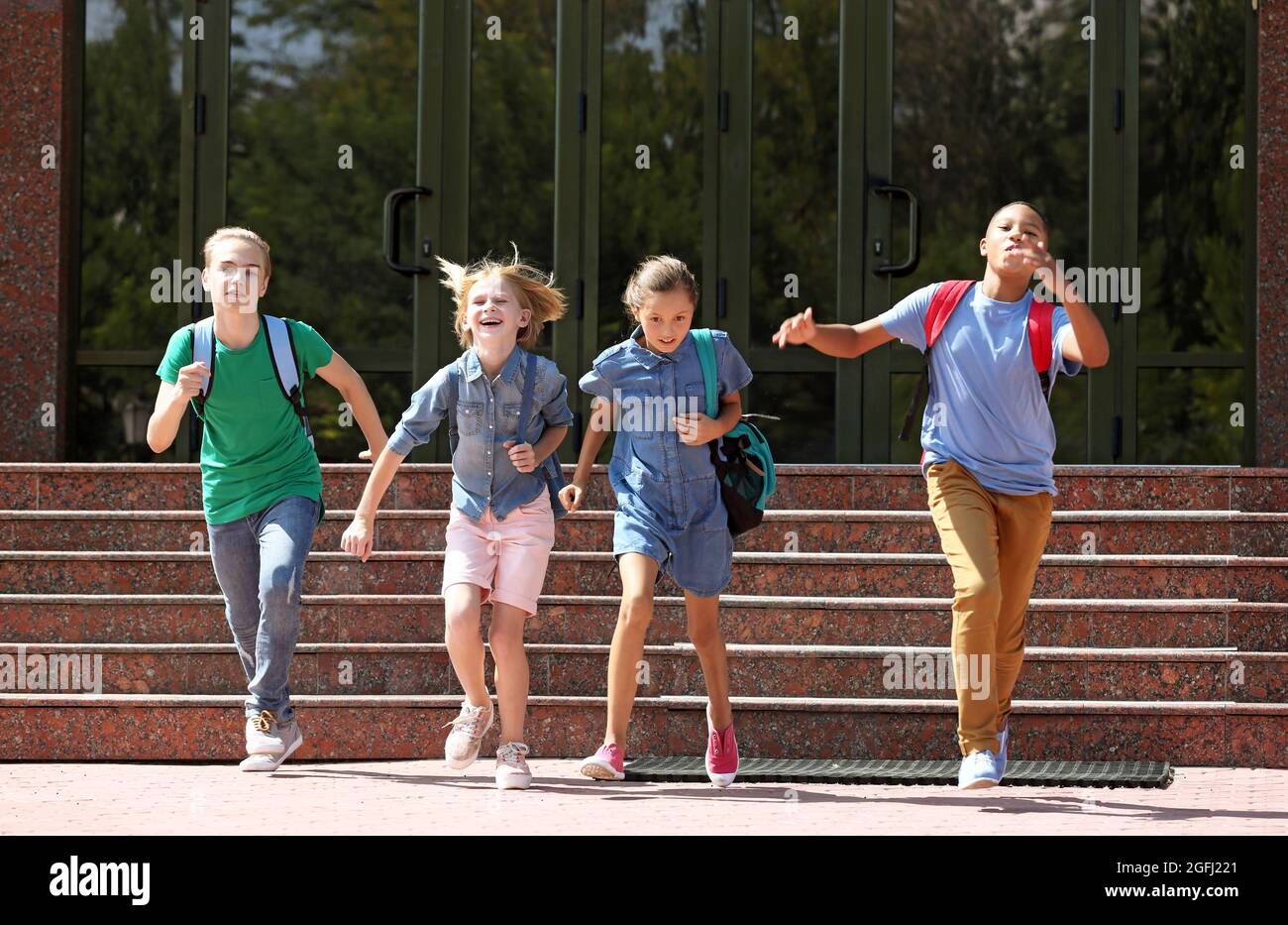 Cute kids running out of school Stock Photo - Alamy