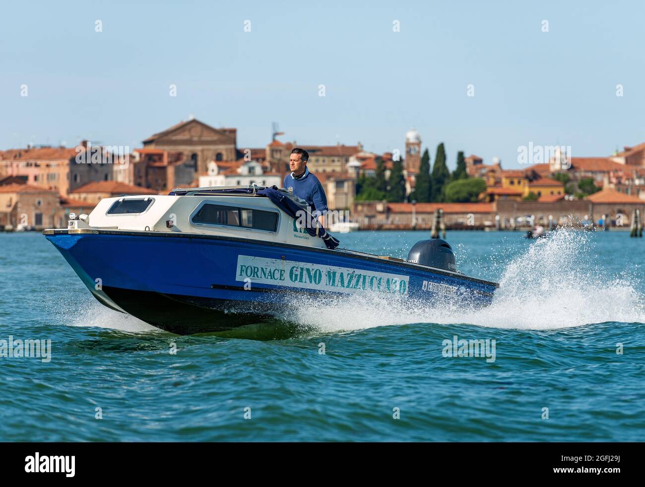 Speedboat with one person on board moving in the Venetian lagoon to the ...