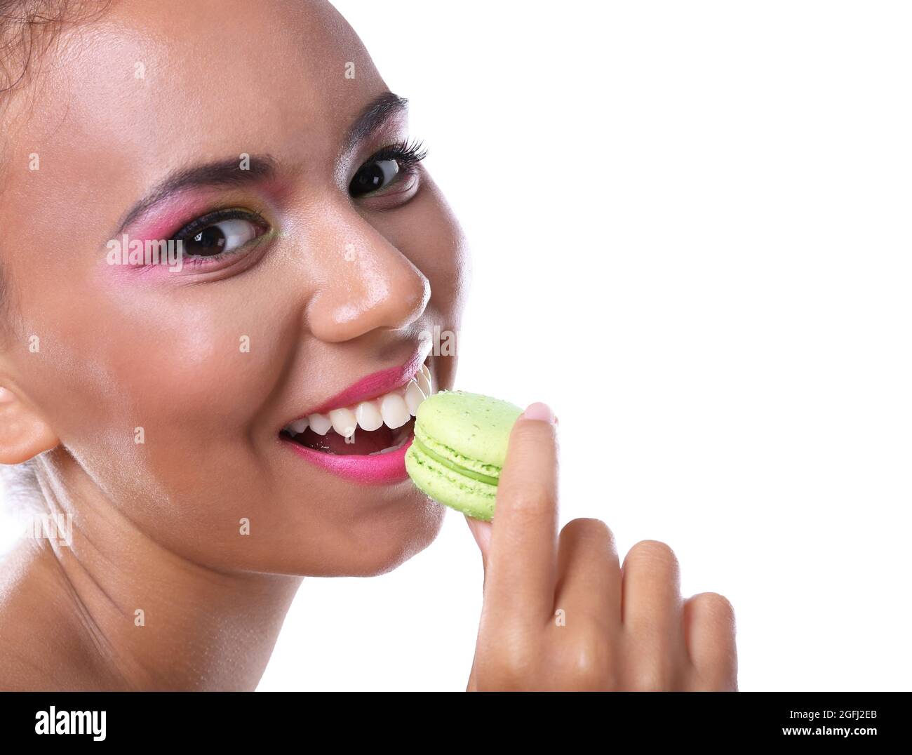 Young woman eating delicious macaroon on white background Stock Photo ...