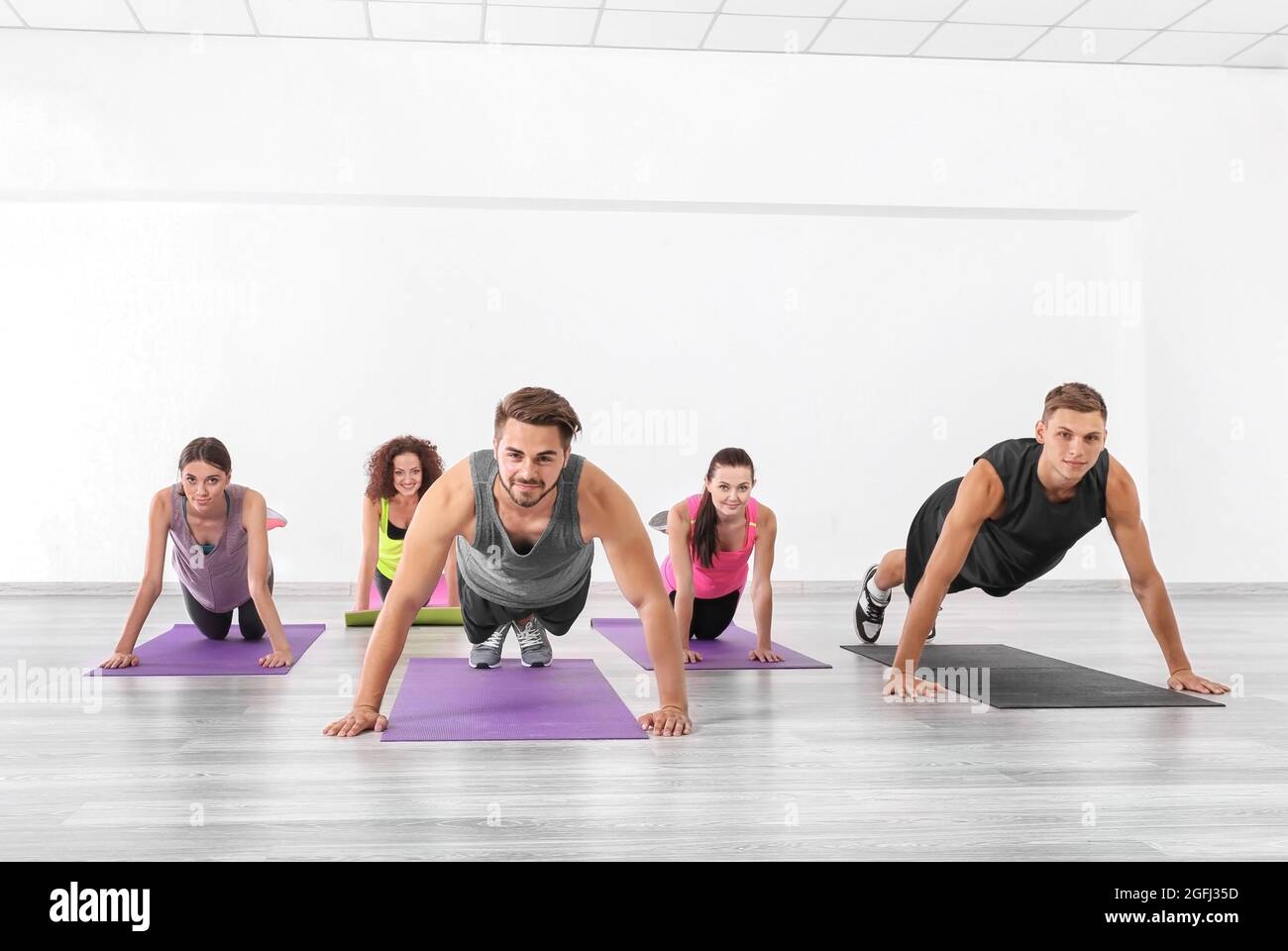 Group of people doing push-ups in yoga class Stock Photo - Alamy