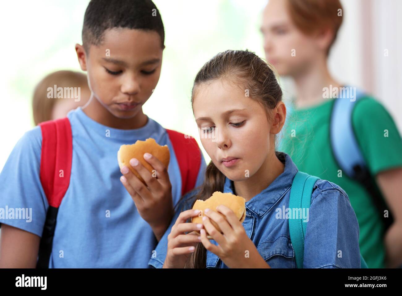 Cute kids eating in school Stock Photo - Alamy