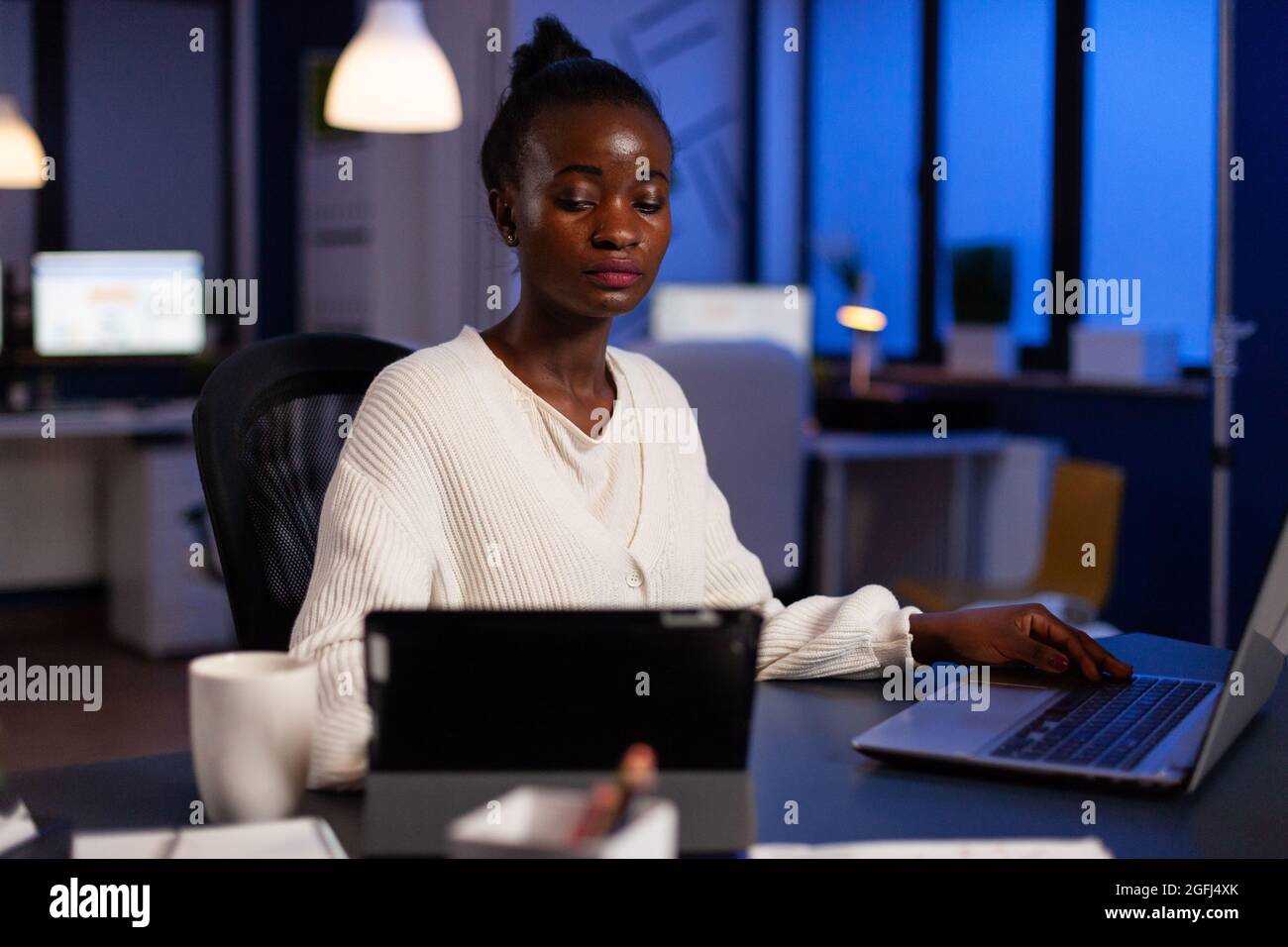 Multitasking focused african american businesswoman planning management strategy on computer ...