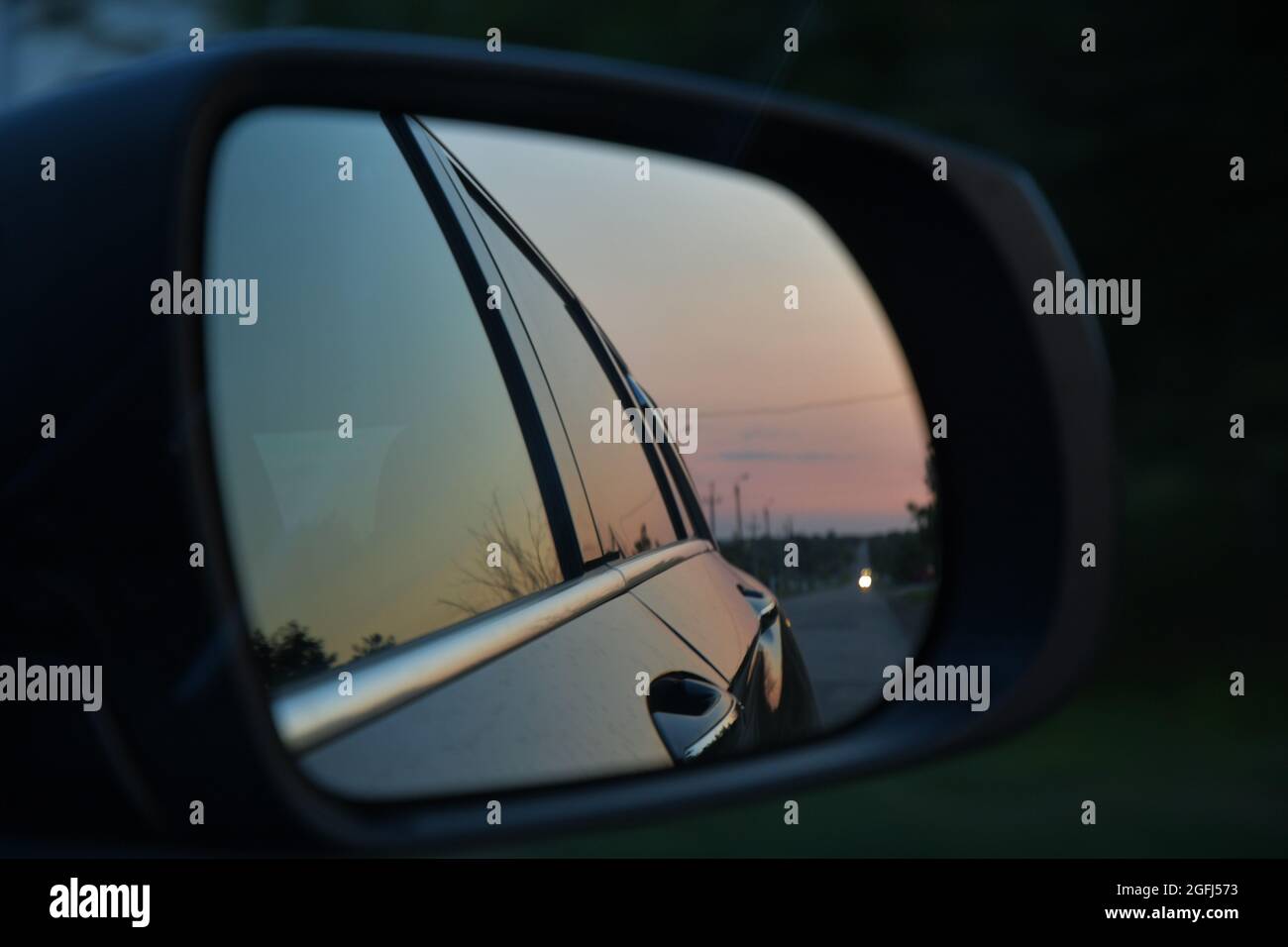 Soft focus view from car window with road reflection into side mirror ...