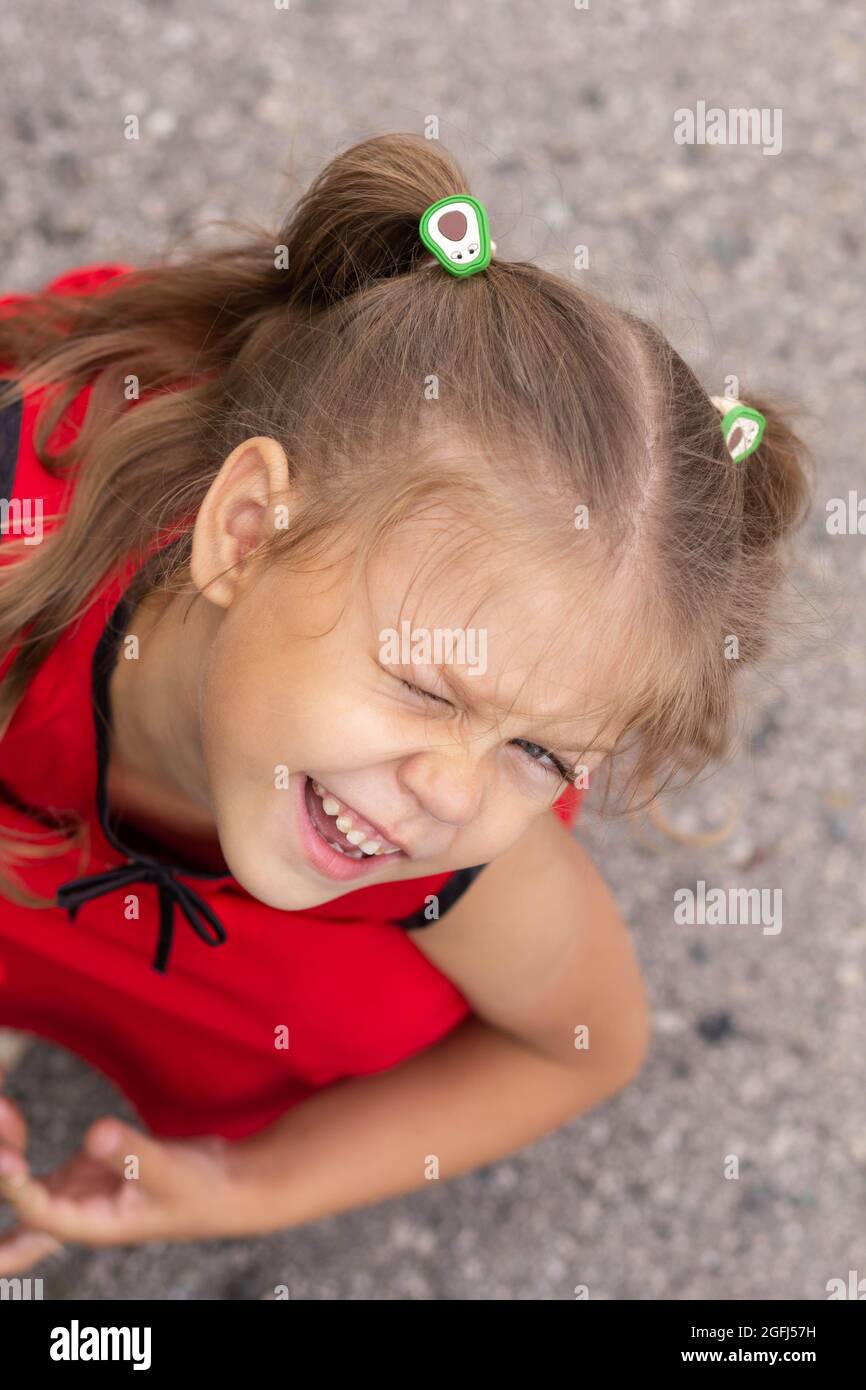 A happy caucasian little girl of five years old winking with close one ...