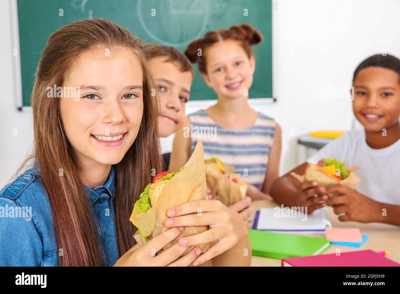 Portrait of schoolgirl having lunch in classroom Stock Photo - Alamy