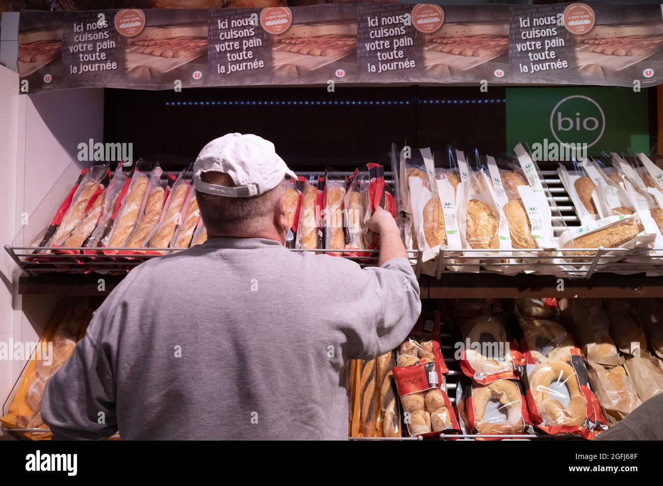 Super U supermarket: man viewed from behind in the bread department ...