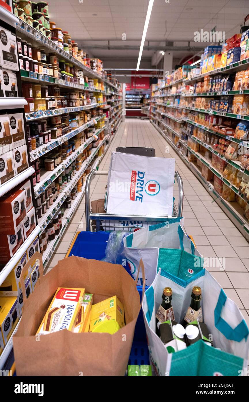 Super U supermarket: woman, order picker / packer selecting products in ...