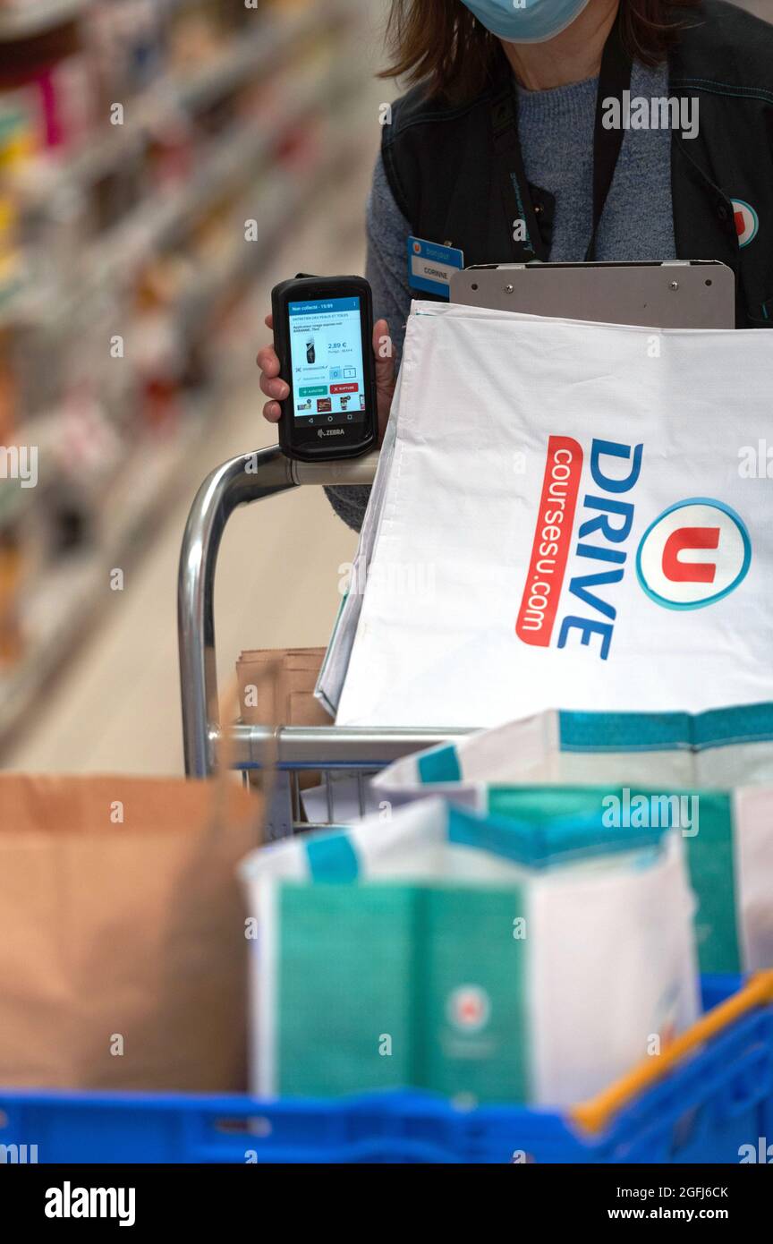 Super U supermarket: woman, order picker / packer selecting products in ...