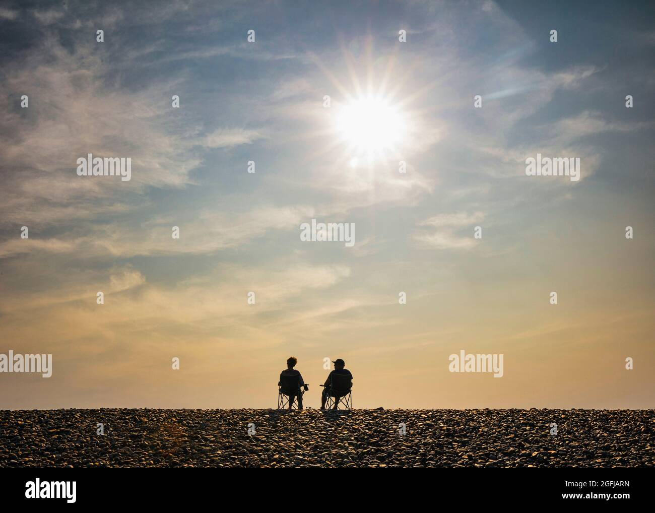 Two people sitting on a beach hi-res stock photography and images - Alamy