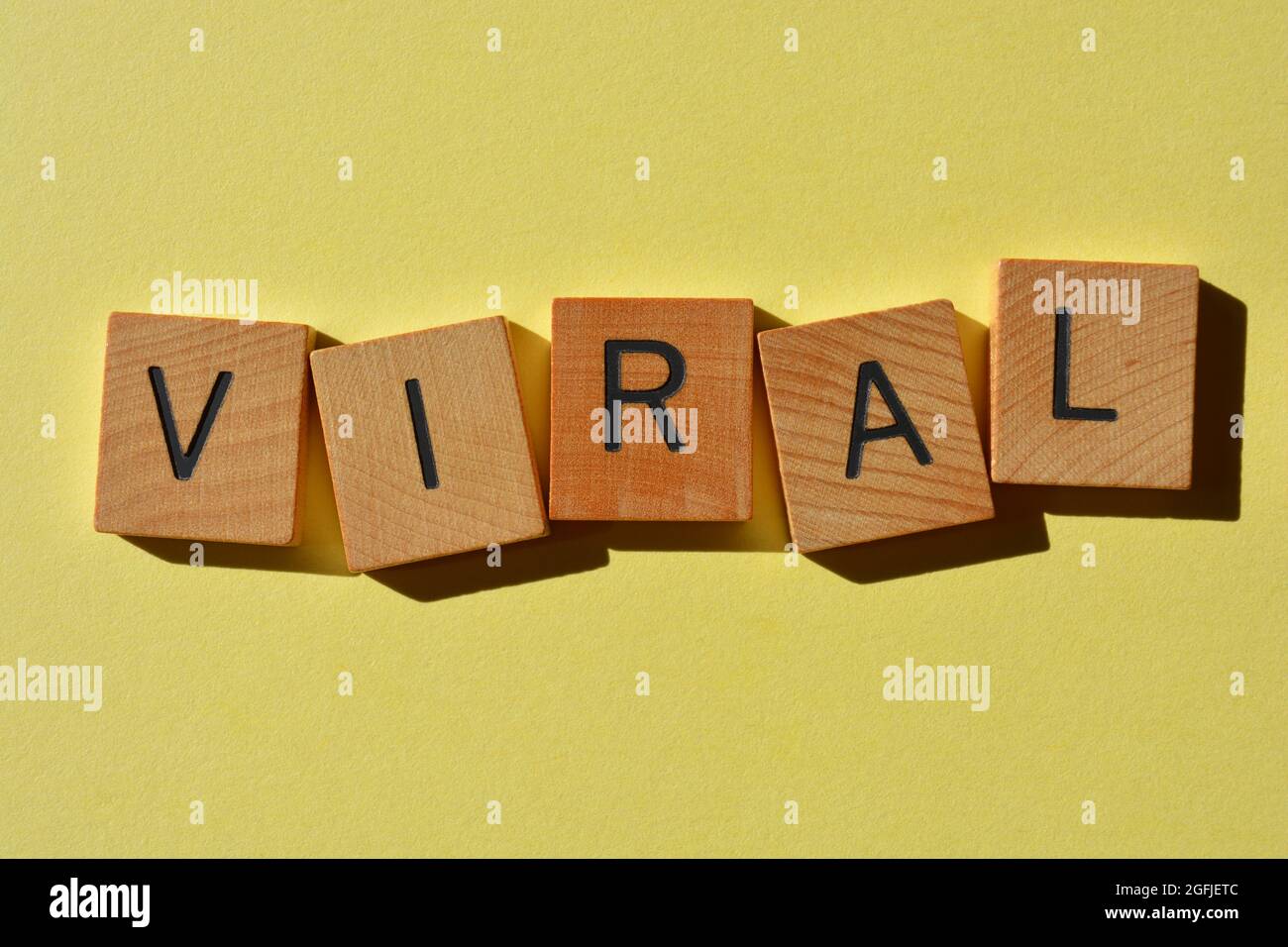 Viral, word in wooden alphabet letters isolated on yellow background ...