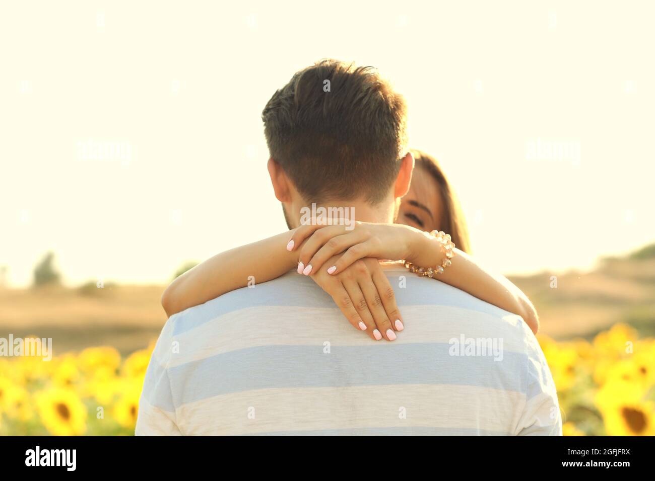 Young man standing back and girl hugging his neck Stock Photo - Alamy