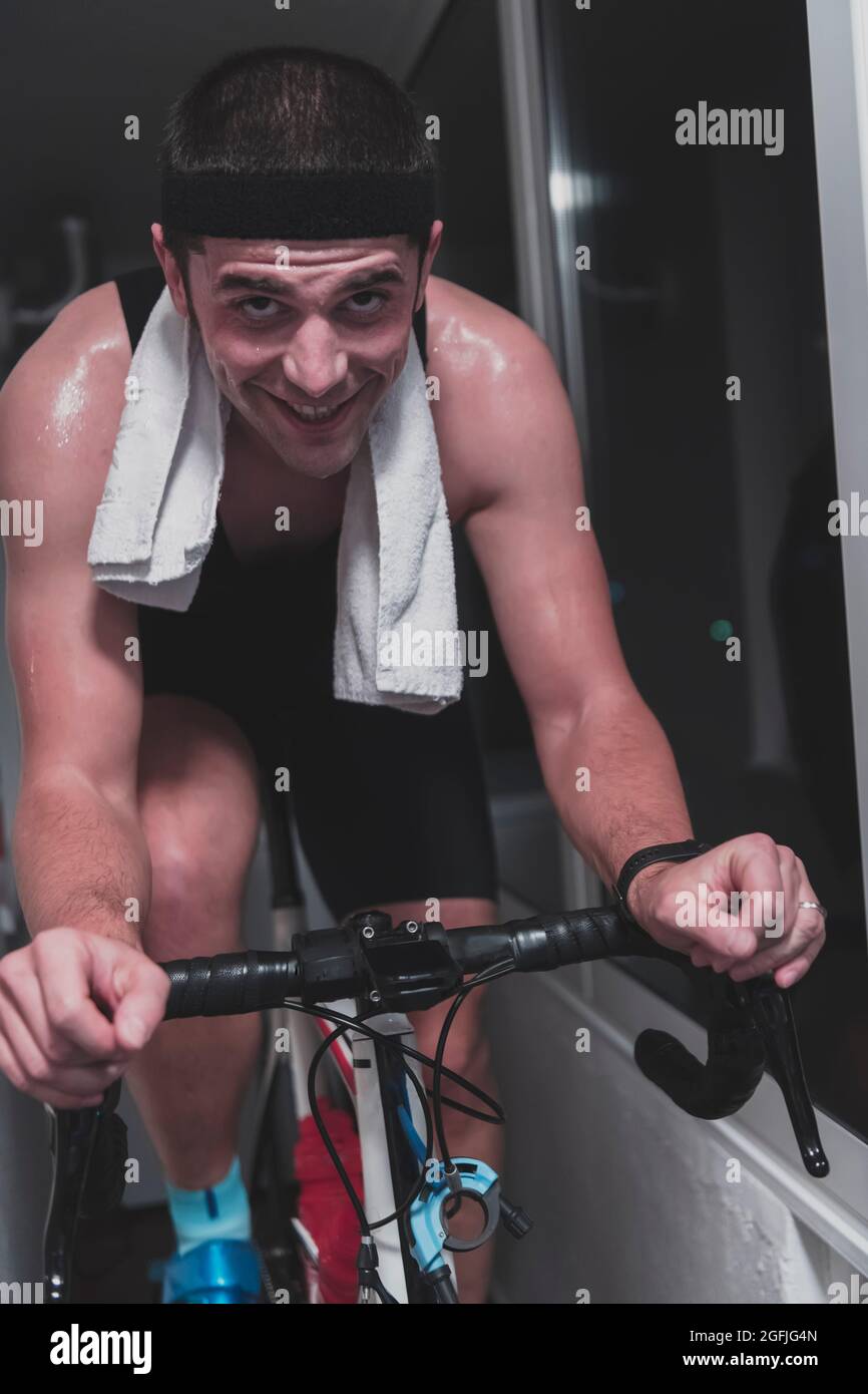 Man cycling on the machine trainer he is exercising in the home at ...