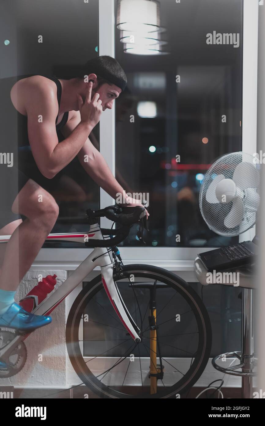 Man cycling on the machine trainer he is exercising in the home at ...