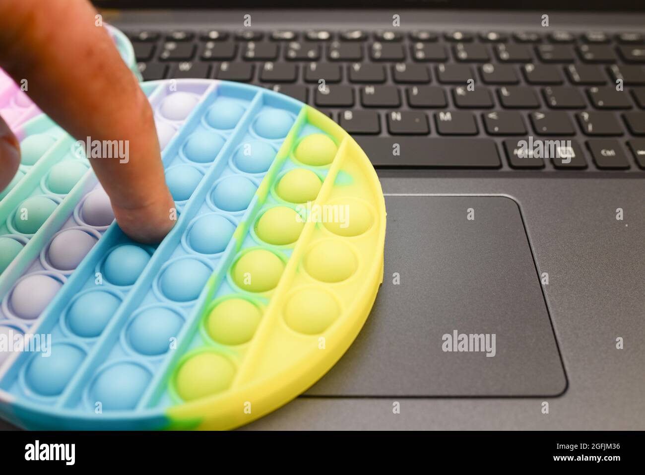 businessman hand near anti stress toys pop it on the keyboard. New ...