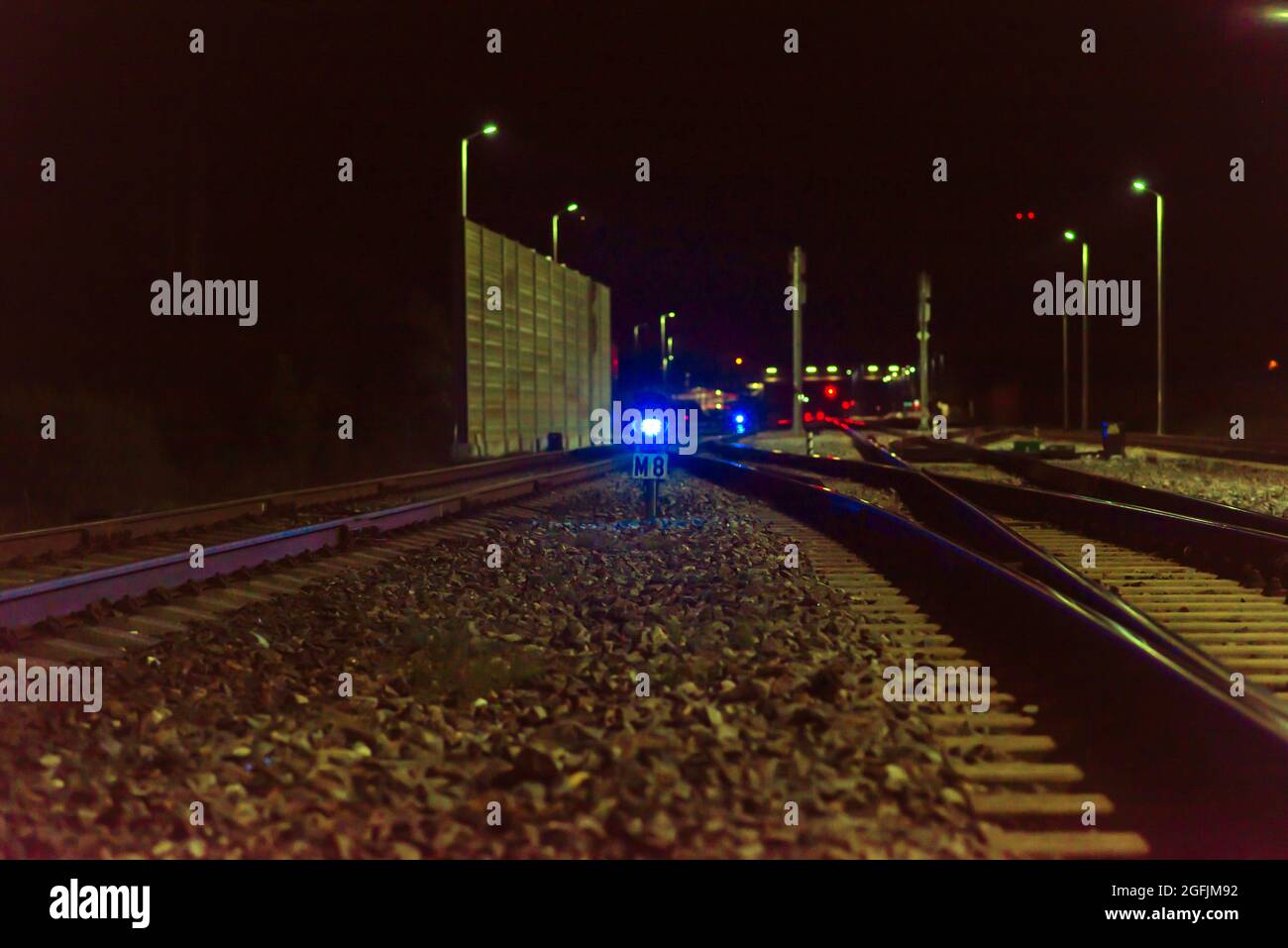 Night empty railroad tracks near train station with lights in dark ...