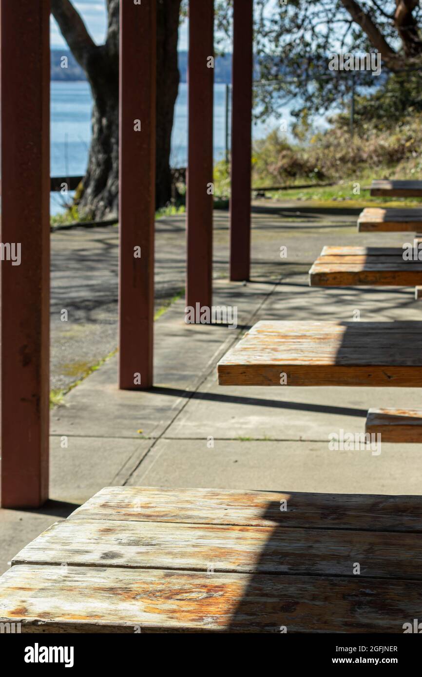 empty picknick tables lined up under a pavilion Stock Photo - Alamy