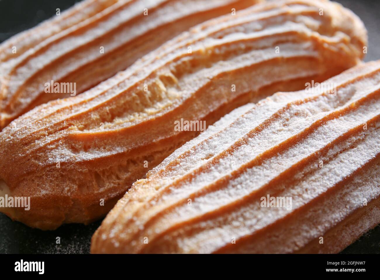 Delicious eclairs with sugar powder, close up Stock Photo - Alamy