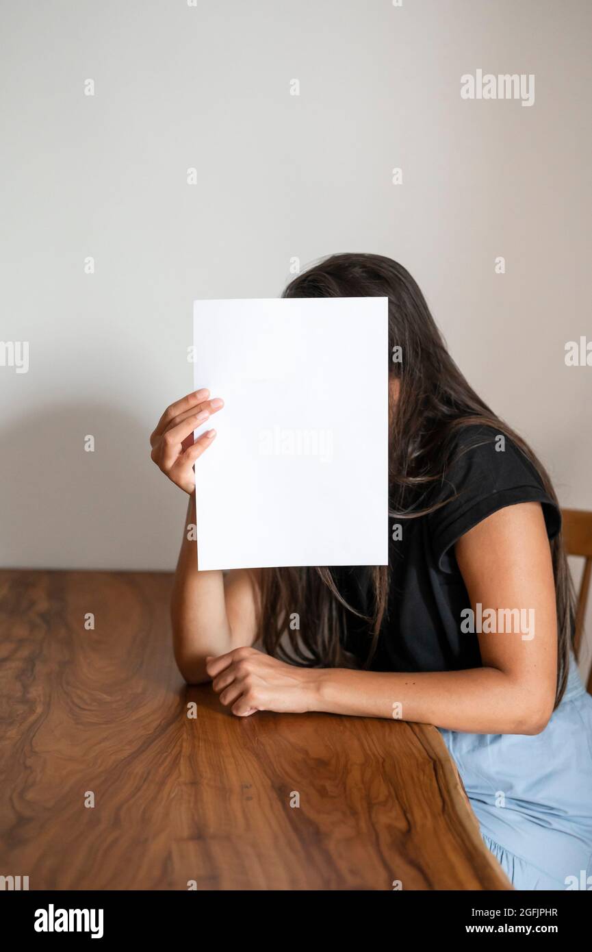 Woman hold a white paper sheet in front of her face Stock Photo - Alamy